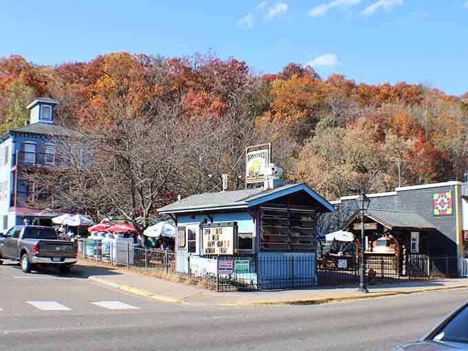 Fall colors explode behind these charming storefronts, proving nature knows how to frame a perfect picture.