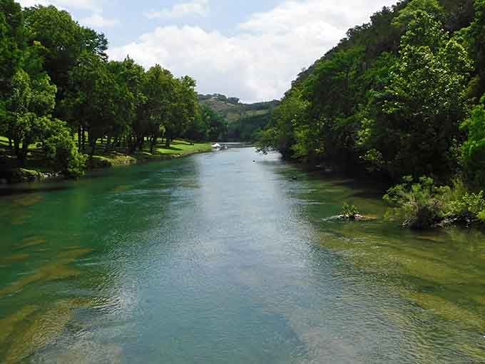 Crystal-clear water flows between lush green banks, creating the perfect natural escape for a lazy summer afternoon.