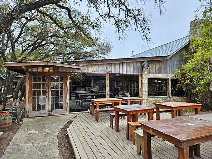 Weathered wood and ancient oak trees frame picnic tables where generations have gathered for unforgettable Hill Country feasts.
