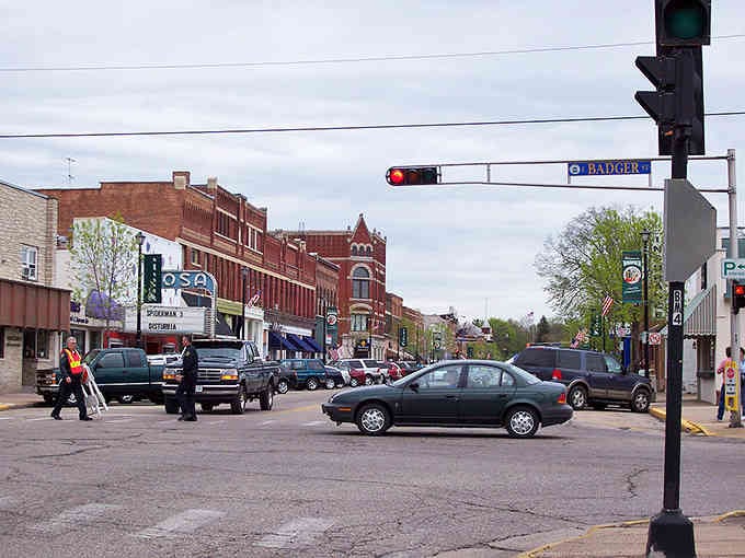 Historic downtown bustles with parked cars and pedestrians, proving small-town shopping still beats scrolling through your phone.
