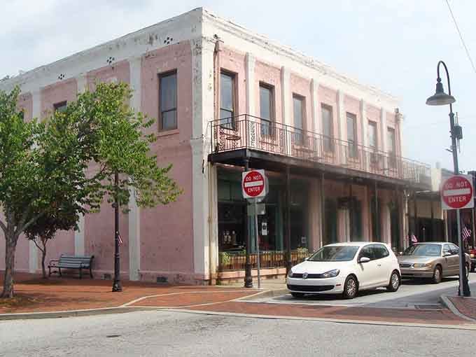 Pink buildings and wrought-iron balconies bring a touch of New Orleans charm to small-town Georgia streets.
