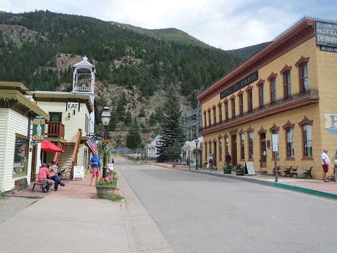 Mountains rise behind historic hotels where mining-era elegance still welcomes travelers seeking authentic Western charm and spectacular views.