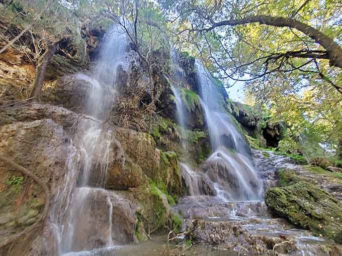 Water cascades over terraced limestone in delicate veils, transforming solid rock into something that looks almost soft.