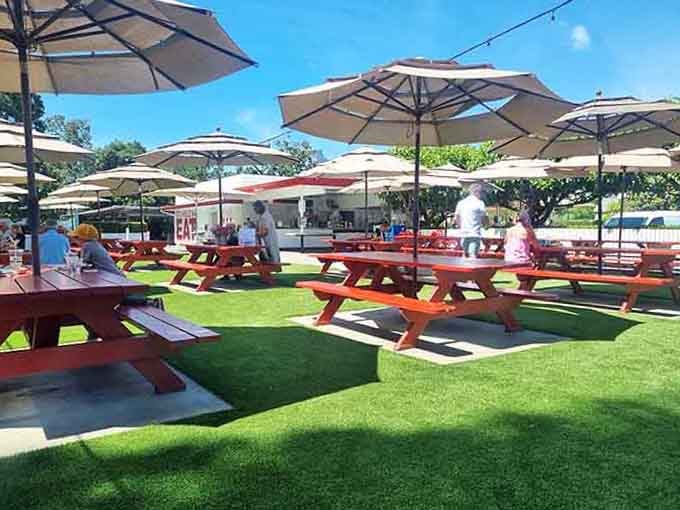 Umbrellas shade happy diners enjoying roadside classics under the warm California sun in Napa Valley's heart.