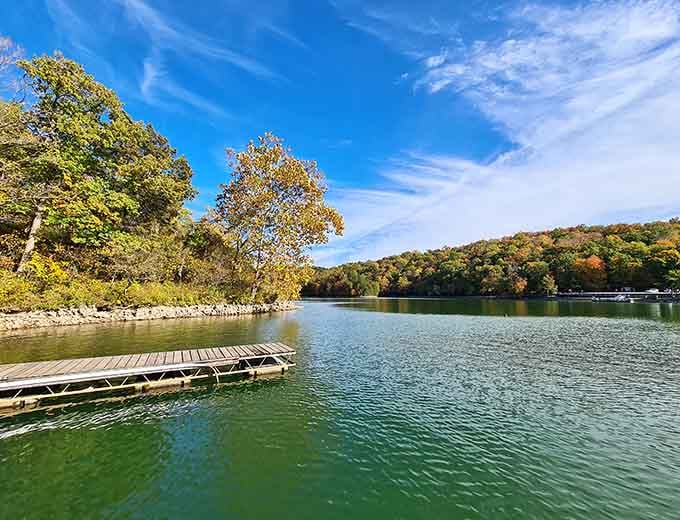 The lake stretches out calm and inviting beneath autumn skies, with rolling hills creating the perfect backdrop.