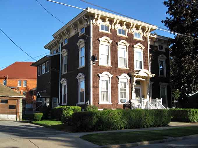 This stately Italianate mansion with its arched windows and manicured hedges proves that elegance once thrived in unexpected small-town settings.