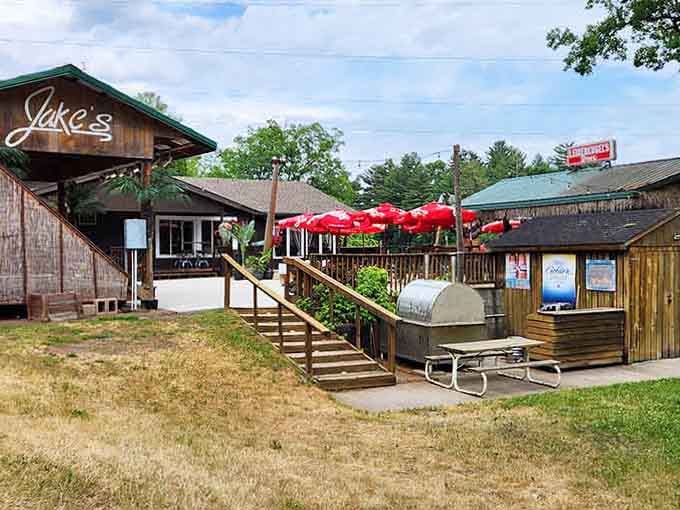 The rustic deck with red umbrellas promises sunny afternoons filled with sizzling steaks and good conversation by the water.