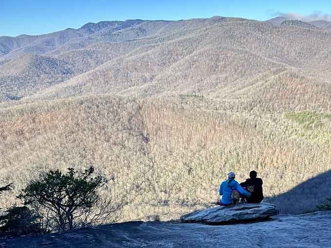 Two friends share mountain majesty from this stone perch overlooking endless Appalachian grandeur.
