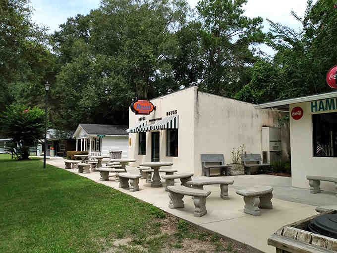 Vintage signs and picnic tables create an outdoor gathering spot where strangers become friends over cold drinks.