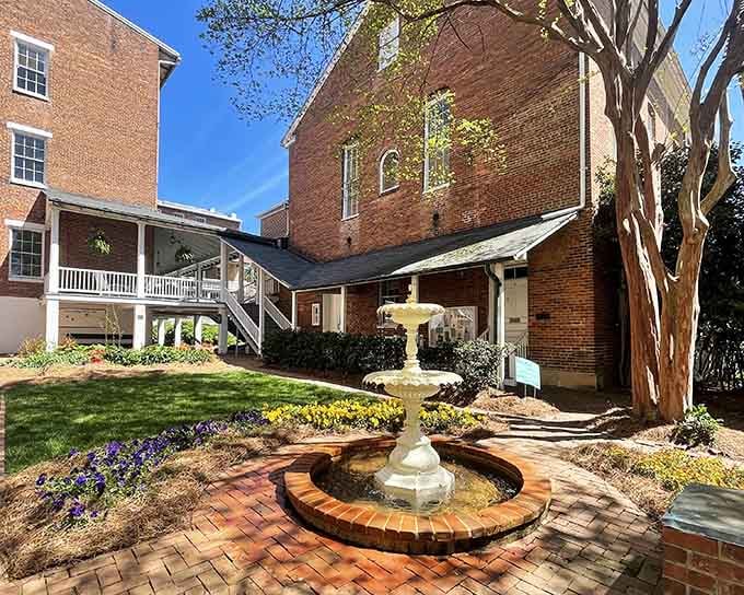 Sunny courtyard fountain surrounded by brick and blooming flowers&mdash;this hidden garden feels like discovering old-world Savannah charm.