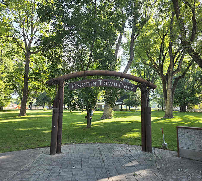 Paonia's town park archway frames towering cottonwoods, inviting you into a community where neighbors still know your name.