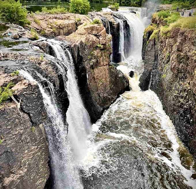 Multiple cascades tumble over ancient volcanic rock, demonstrating the raw power that once drove America's industrial revolution forward.