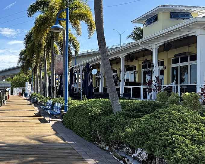 Palm-lined boardwalk beckons visitors toward the waterfront entrance where fresh catches and river views await discovery.