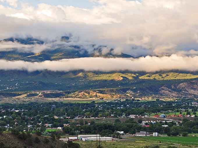 Low clouds drift across the valley like cotton batting, softening the dramatic peaks that cradle this artistic mountain community below.