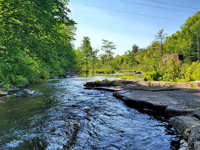 Smooth rock ledges stretch across the river, creating natural platforms for contemplating the beauty of moving water.