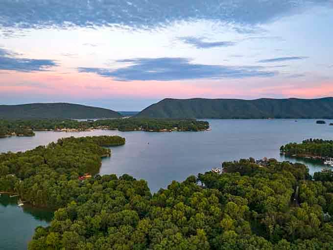 Pastel sunset colors wash over forested islands, transforming the lake into a painter's dream canvas.