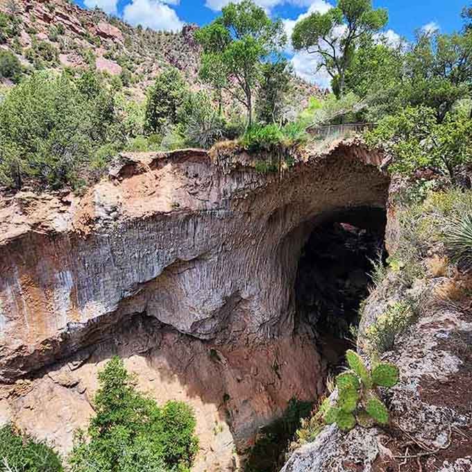 The travertine formations create a cave-like opening that's both mysterious and surprisingly welcoming to curious explorers.