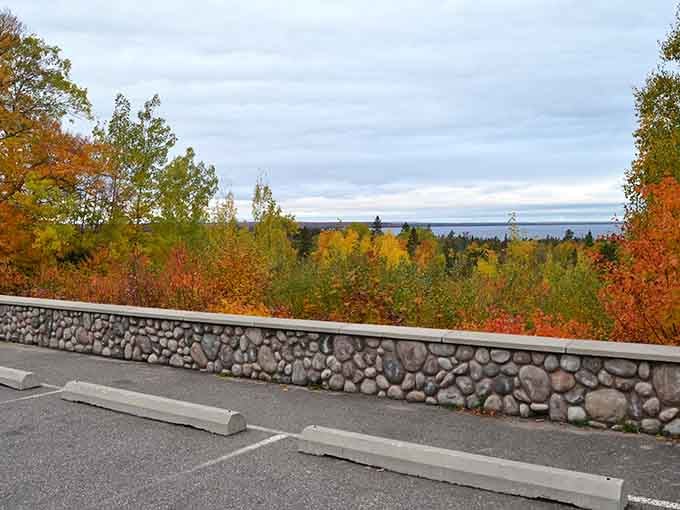 Stone walls frame autumn's spectacular show while Lake Superior stretches endlessly toward the distant horizon beyond.