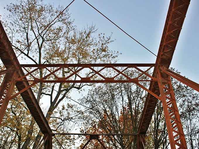 Overhead trusses crisscross against autumn sky, creating patterns that would make any geometry teacher weep with joy.