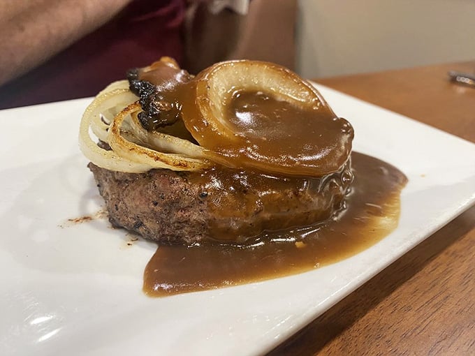 Hamburger steak swimming in gravy with caramelized onions, the kind of plate that makes your cardiologist nervous and you deliriously happy.