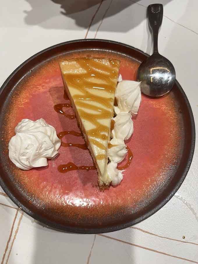 Caramel cheesecake drizzled with sauce, because apparently you found room for dessert after all that steak.