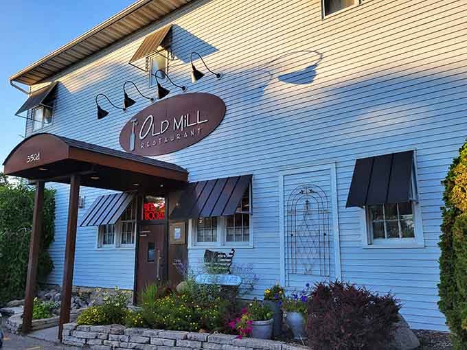 The Old Mill Restaurant's blue clapboard exterior promises hearty meals in a setting that feels like coming home.