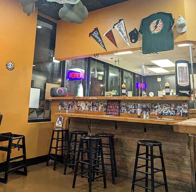 Booth seating with Raleigh artwork overhead, because even giant pizza deserves a proper dining atmosphere.