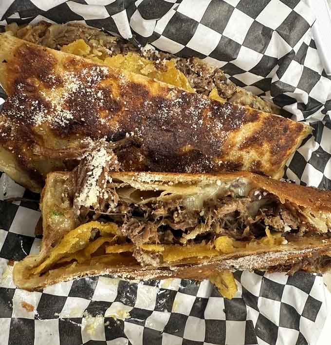 The birria crunchwrap delivers crispy, cheesy, meaty satisfaction in every single bite, dusted with parmesan for good measure.