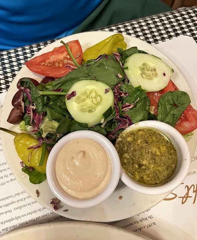 Fresh salad with pepperoncini and two dressings, because even legendary seafood restaurants understand the importance of vegetable diplomacy.