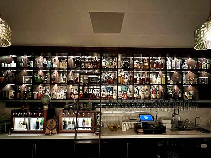 The bar's moody lighting transforms premium spirits into liquid art, which is exactly how they should be displayed anyway.