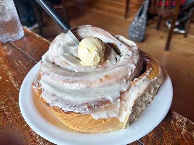 That cinnamon roll is roughly the size of a hubcap and topped with enough frosting to require its own zip code.