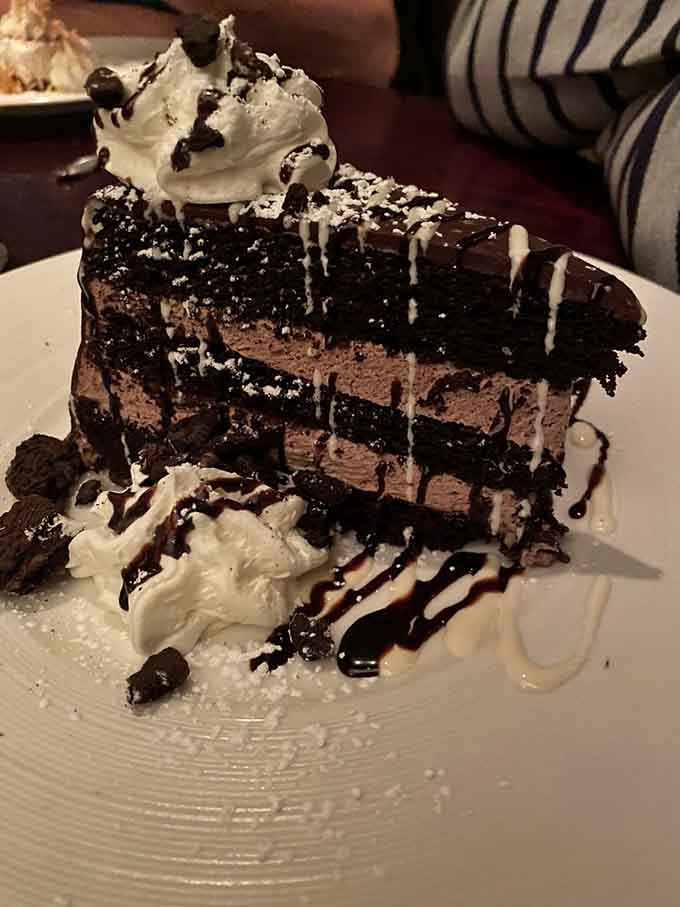 This towering chocolate cake defies physics and portion control, making every calorie absolutely worth the delicious consequences ahead.
