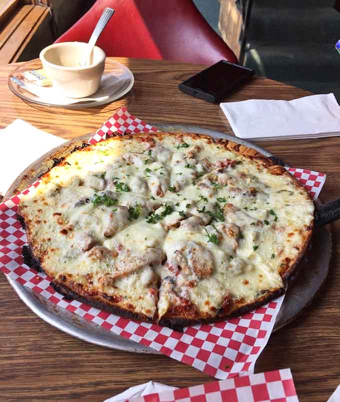 The chicken artichoke flatbread emerges bubbling with cheese, herbs, and enough flavor to make pizza jealous of it.