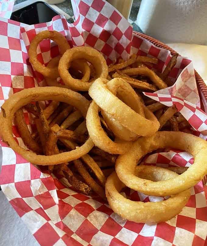 Golden onion rings and crispy fries sharing space like the best buddy comedy you've ever tasted in basket form.