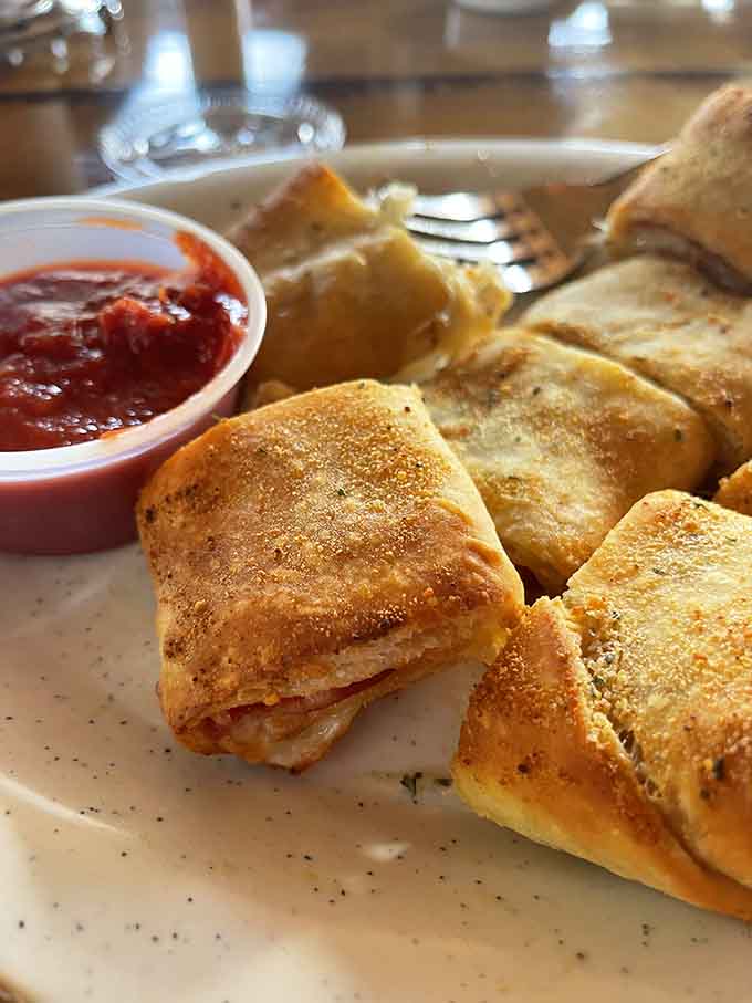Golden calzone wedges served with marinara prove that portable pizza pockets deserve their own moment of glory.