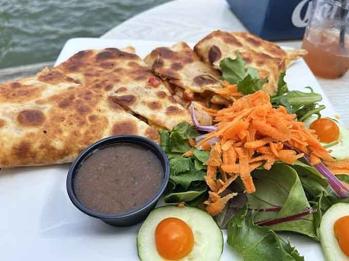 A quesadilla served waterside with fresh greens, because even casual bites deserve a proper presentation here.
