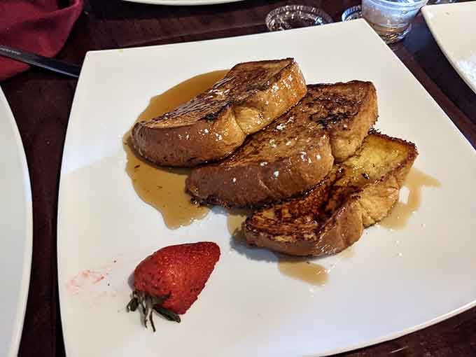 French toast thick enough to require structural engineering, syrup pooling like liquid gold on the plate.