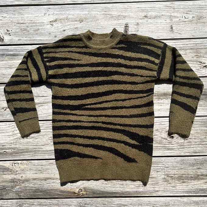 Horizontal stripes in olive and black give this cozy knit sweater that timeless Mister Rogers meets modern sophistication vibe.