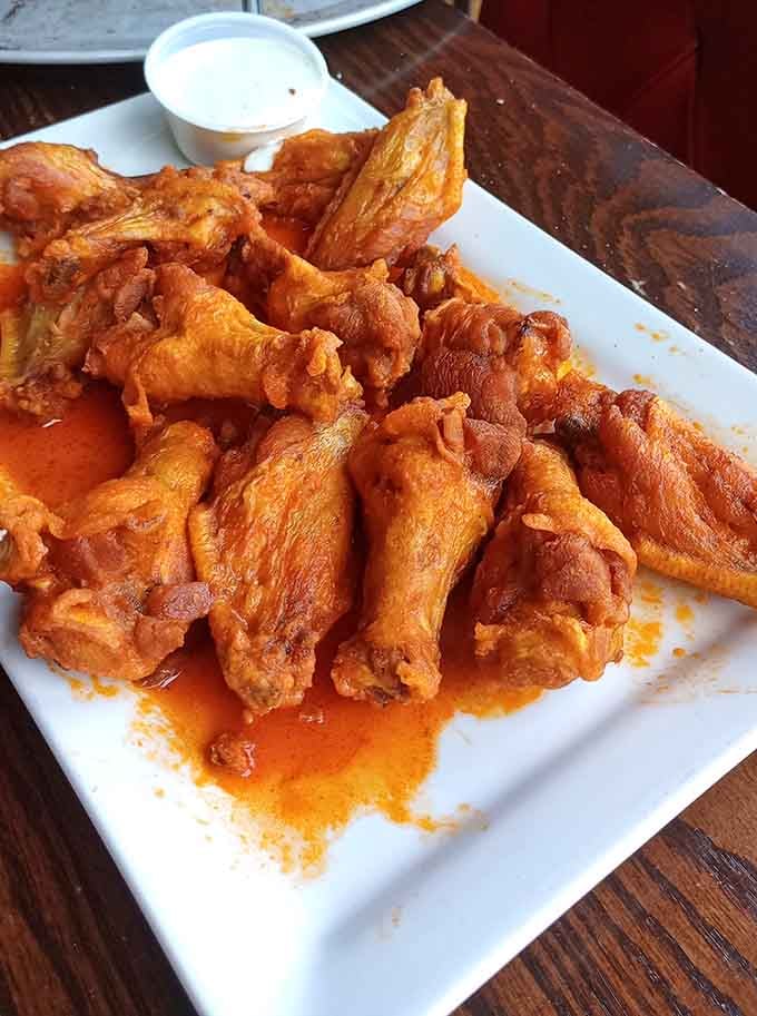 Buffalo wings coated in sauce so vibrant orange they practically glow, promising heat and flavor in equal measure.