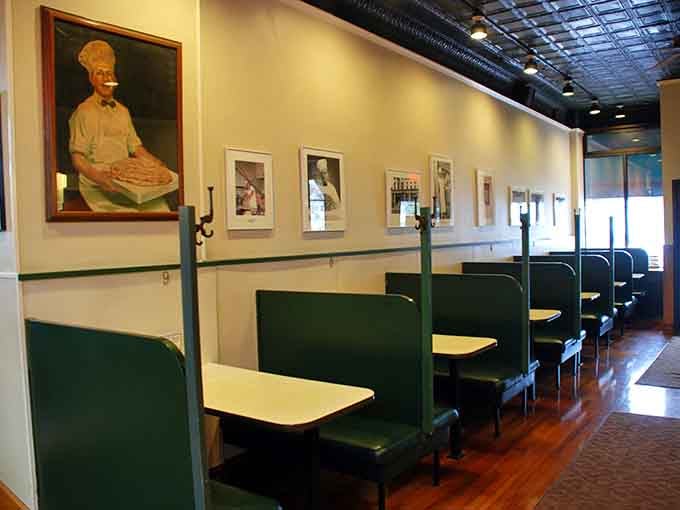 Green booths and vintage portraits create a dining room that feels like stepping into your favorite uncle's time machine.