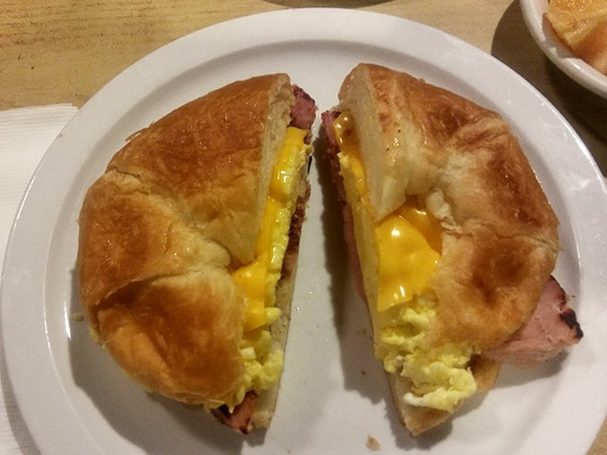 Breakfast sandwich on a croissant stuffed with eggs, bacon, and cheese, portable morning happiness wrapped in flaky layers.