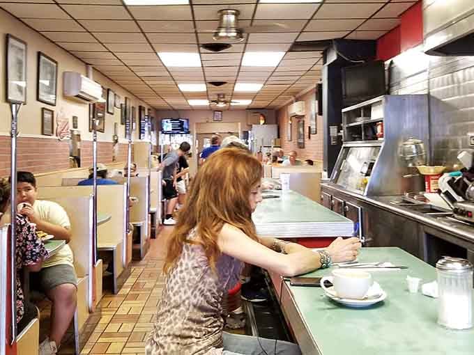 Counter seating where strangers become friends over coffee refills and shared appreciation for perfectly cooked eggs.
