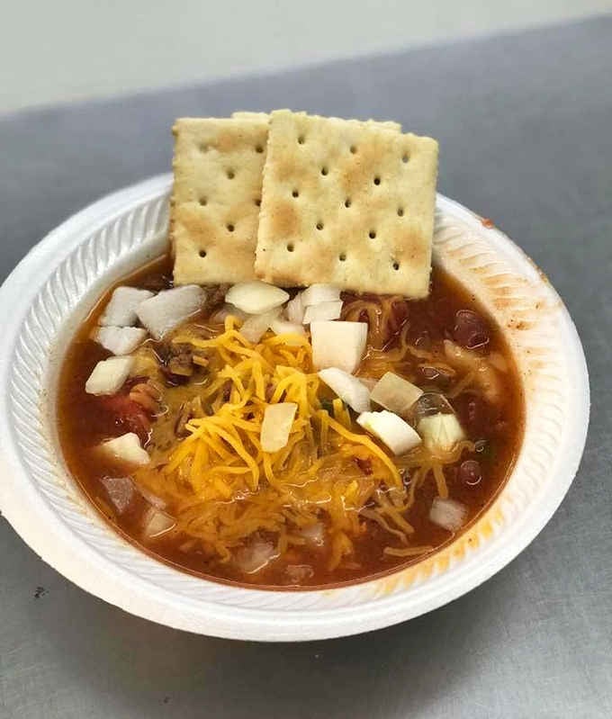 Chili topped with crackers standing at attention like tiny soldiers guarding a bowl of comfort.