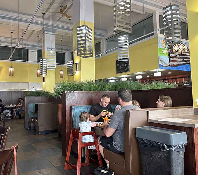 Families gather in cozy booths under modern lighting, creating the kind of warm atmosphere where memories are made over meals.