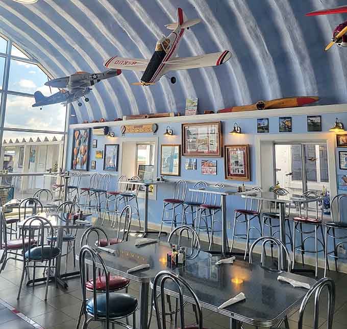 Chrome chairs and retro tables beneath a sky of vintage aircraft, like dining in a 1950s diner that learned to fly.