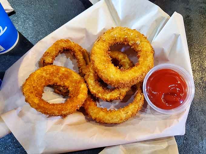 Golden onion rings arranged like edible halos, because sometimes fried food deserves angelic treatment and ketchup worship.