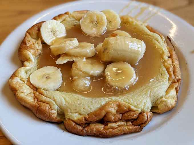 Banana pannekoeken drizzled with syrup: thin, golden, and about to make regular pancakes feel deeply inadequate forever.