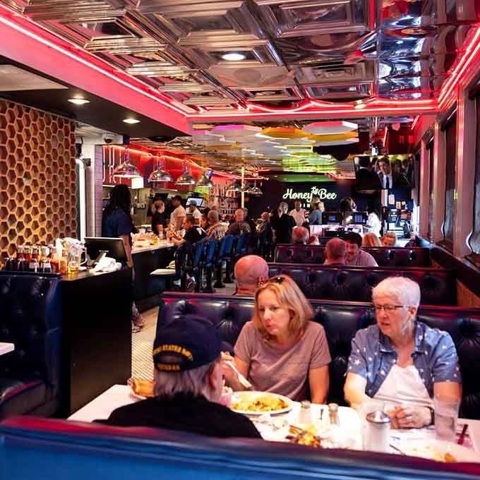 Happy diners in cozy booths, living proof that good food creates the best kind of gathering spot.