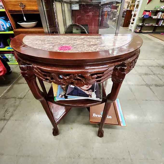 This carved table has more curves than a mountain highway and twice the character of modern furniture.