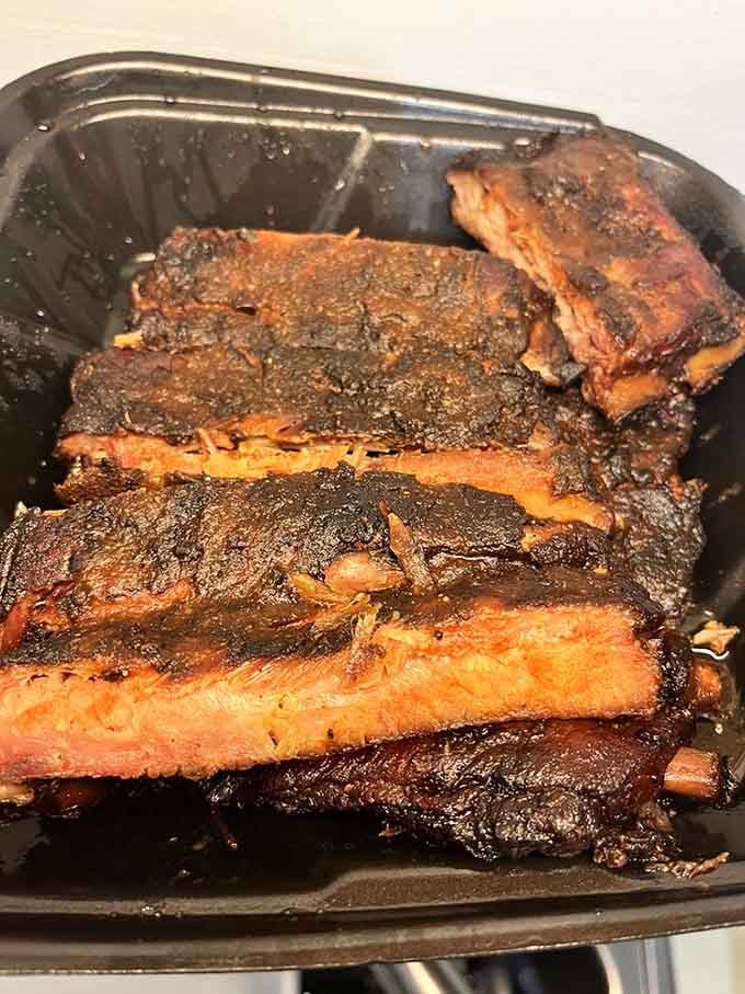 A full rack of ribs with that bark so perfect it looks like edible art, ready for its close-up.